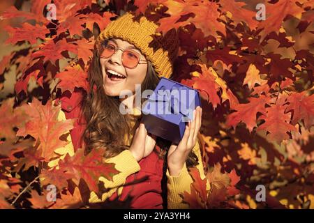 Amazed teenager. Child with gift present box on isolated background ...