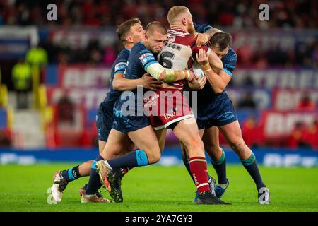 Wigan Warriors' Luke Thompson is tackled by Hull FC's Amir Bourouh and ...