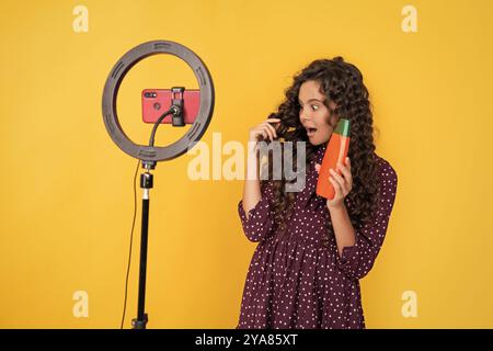 shocked teen girl presenting shampoo or hair body conditioner bottle ...