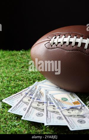 American football ball and dollar banknotes on green grass Stock Photo ...