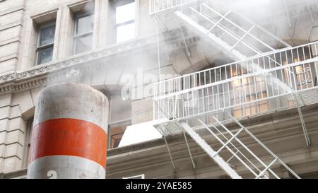 Steam vapor vented on New York City street, orange vapour tube stack ...