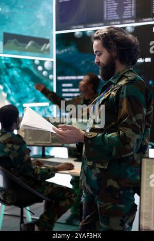 Special operations engineer examining surveillance CCTV footage to ...