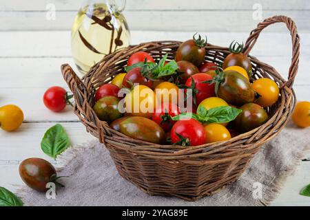 Multi-colored tomatoes in wickerwork basket. Different types of fresh ...