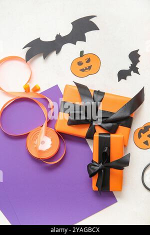 Halloween decorations with gift boxes and wrapping paper on white ...