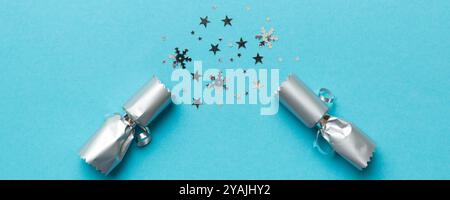 Christmas crackers with shiny confetti on color background, top view ...
