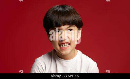 Child displays fierce, energetic expression, teeth showing in moment of ...
