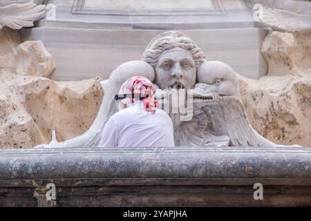 A restoration worker works on cleaning the marble statues from the ...