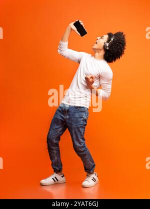 Emotional black man singing his favorite song on smartphone Stock Photo ...