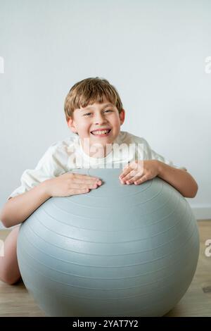 Adorable 10 year old boy does sports with fitness ball at home. Home ...