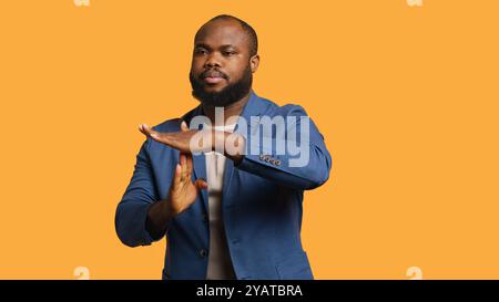 Portrait of assertive BIPOC man asking for timeout, doing hand gestures ...