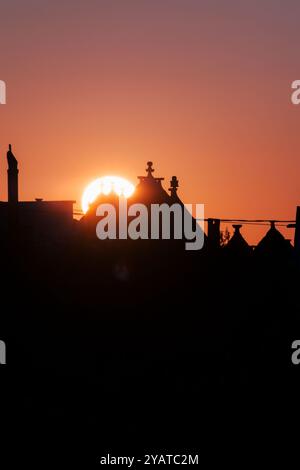The sun sets behind the roofs of the Trulli at Alberobello Stock Photo ...