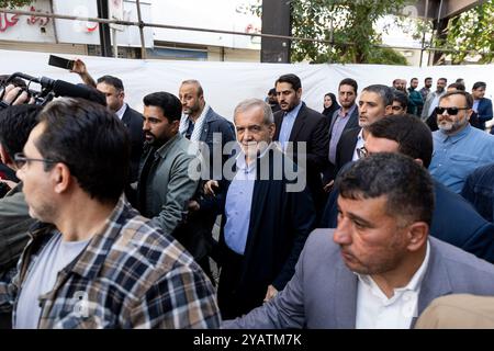 Iranian President Masoud Pezeshkian, center, attends a protest ...