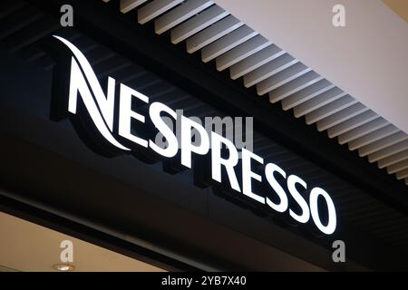 Close-up of Nespresso logo sign mounted on stone building facade under ...