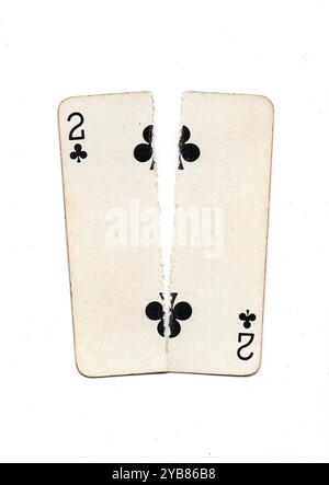 A vintage playing card torn in half from top to bottom on a white ...