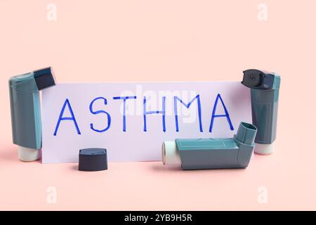 Composition with inhalers and piece of paper with text ASTHMA on blue ...