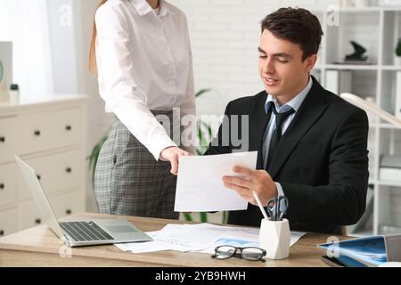 Male economist and secretary working with diagrams in office Stock ...