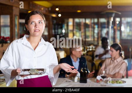 Waitress disappointed in small tip from guests Stock Photo - Alamy
