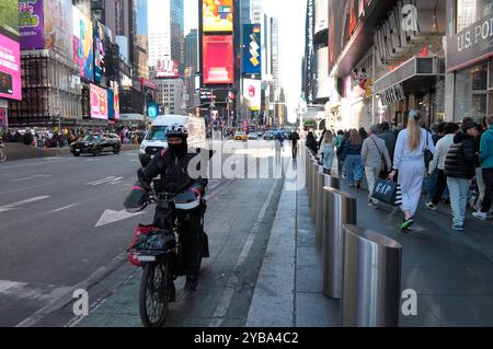 A person rides a bicycle through Times Square, Manhattan, New York City ...