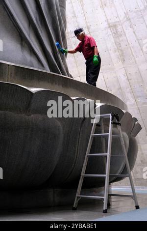 A maintenance worker cleaning the Buddha statue in the Hill of the ...
