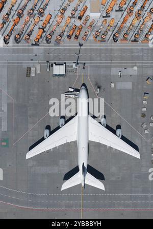 Airplane parked on airport tarmac with boarding stairs and passengers ...