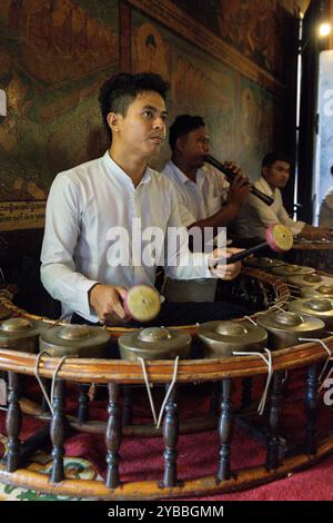 Playing Cambodian traditional musical instrument Kong toch at Wat Phnom ...