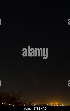 Periodic comet Tsuchinshan Atlas C 2023 A3 photographed in the night sky with city lights on the ...