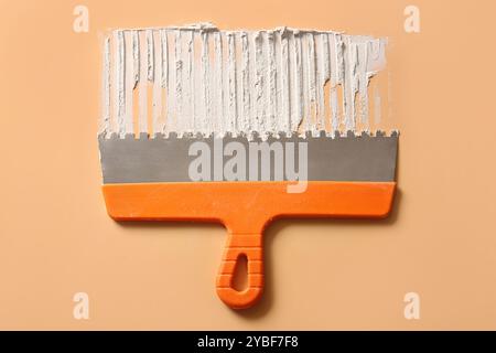 Knife with putty on beige background Stock Photo - Alamy