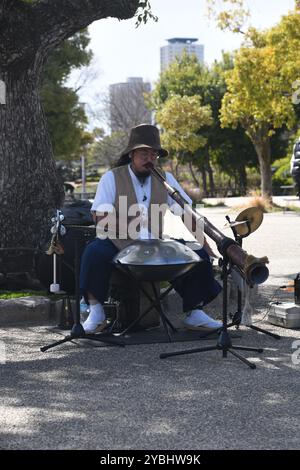 Japanese man playing handpan and singing on the street in Osaka, Japan ...