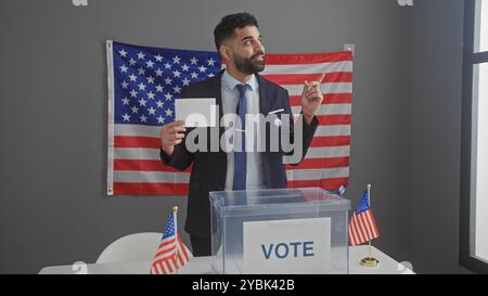 Young hispanic man at political election sitting by ballot smiling with ...