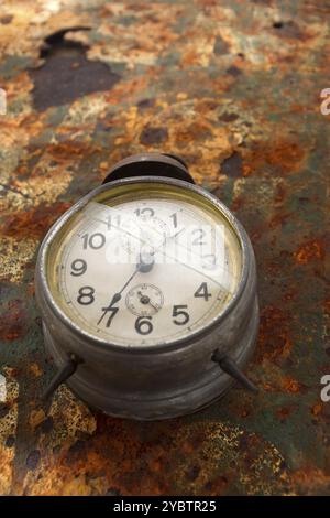 Old alarm clock resting on rusty metallic background Stock Photo - Alamy