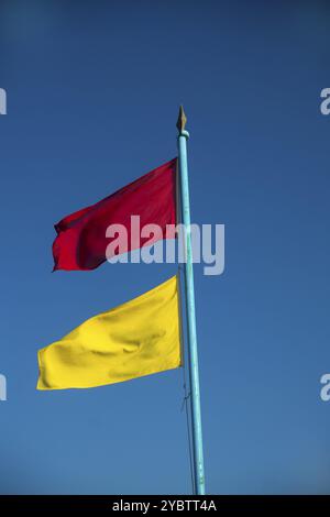 red and yellow danger warning flags on beach life saving guards safety ...
