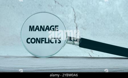 MANAGE CONFLICTS words through a magnifying glass on the wall. Concept ...