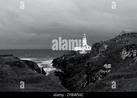 Monochrome photograph of rugged coastal rocks with sharp cracks and ...