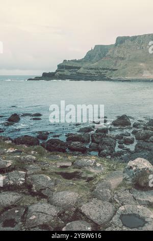 A vertical shot of a rocky shore under a cloudy sky at sunset Stock ...