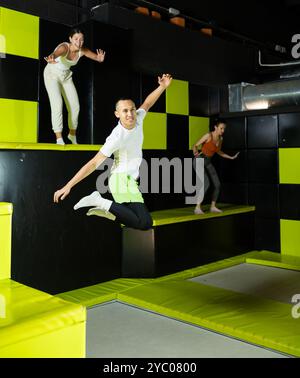 Emotional man jumping vertical and flying in trampoline sport center ...