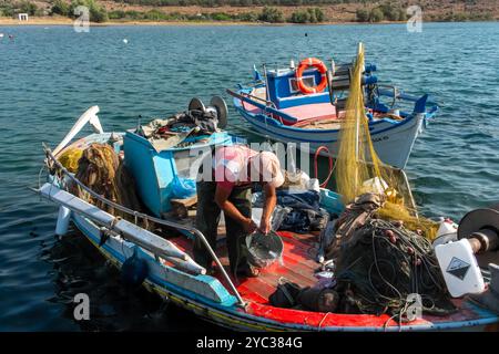 Lesbos scenes. Small Greek fishing boat with family aboard, low in the ...