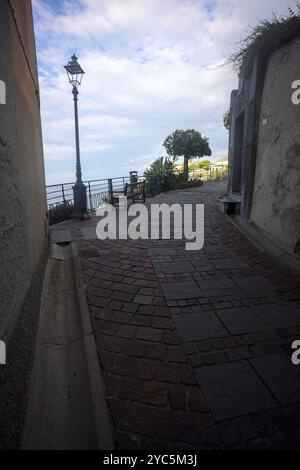 Promenade by the sea bordered by boundary wall of houses in the morning ...