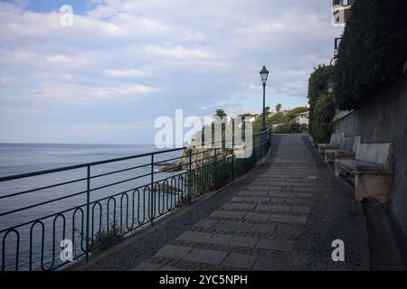 Promenade by the sea bordered by boundary wall of houses in the morning ...