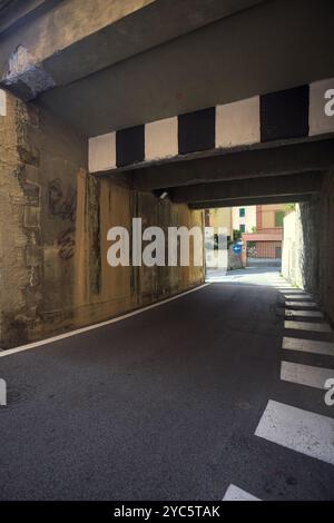 Narrow passage going under a viaduct in a street of an italian town ...