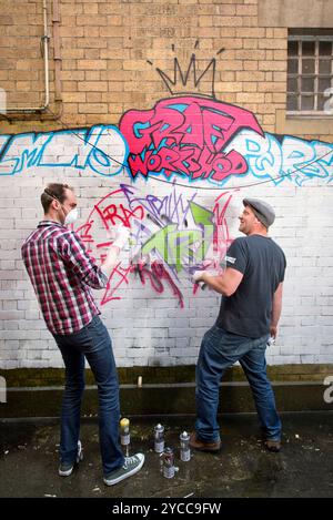 The artist Rob Wheeler (right) sketching designs during a graffiti ...