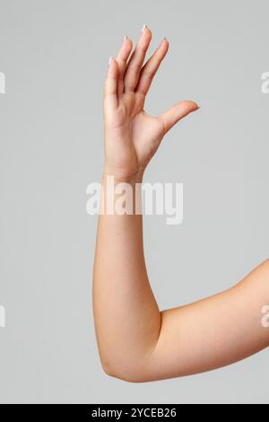Raised hand against a neutral background in a softly lit setting Stock ...