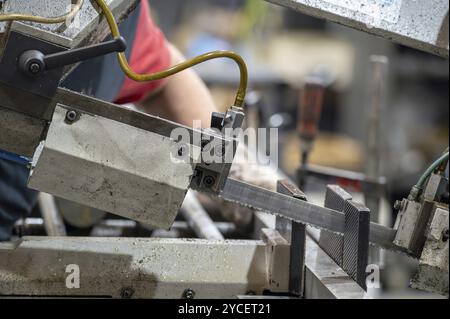 Automatic band saw machine cutting the metal rod with water base ...