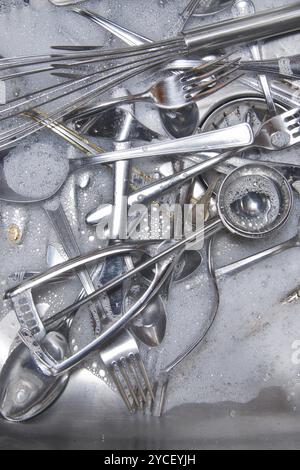 Sink with cutlery ready to be washed Stock Photo - Alamy