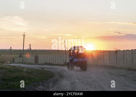 A tractor leaving the village's road during dawn Stock Photo - Alamy