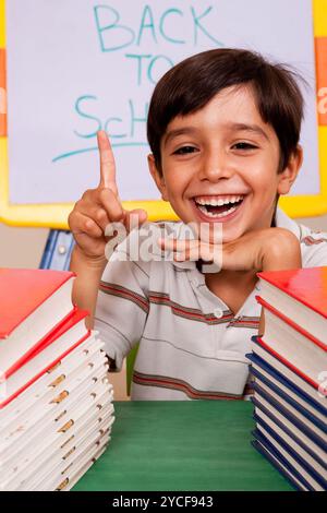Young schoolchild pointing up portrait. Preteen schoolgirl looking at ...