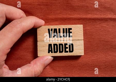 Value added message written on black paper with red background ...