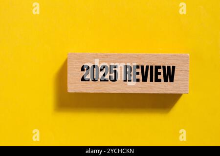 2025 review message written on wooden blocks with pink background. Conceptual 2025 review symbol ...
