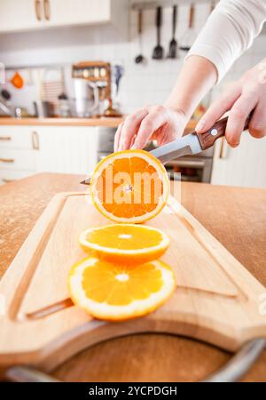 Woman's hands cutting orange Stock Photo - Alamy