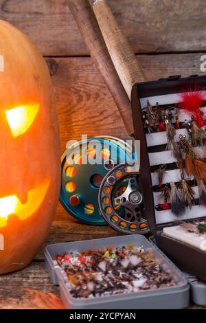 halloween pumpkin head with fly-fishing tackles on wooden boards ...