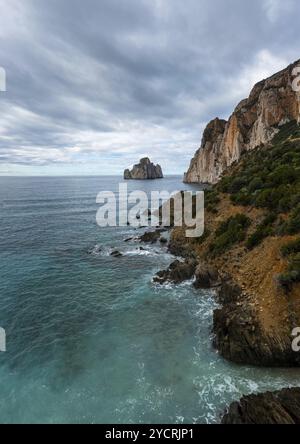 A vertical shot of rocky cliffs on the beach Stock Photo - Alamy